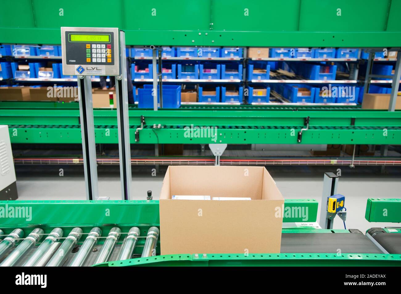 Pharmaceutical drug warehouse. Drugs being weighed on a conveyor belt ...