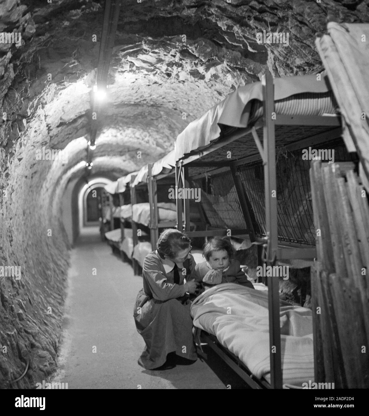 World War II air raid shelter, London Underground. A woman with a young ...