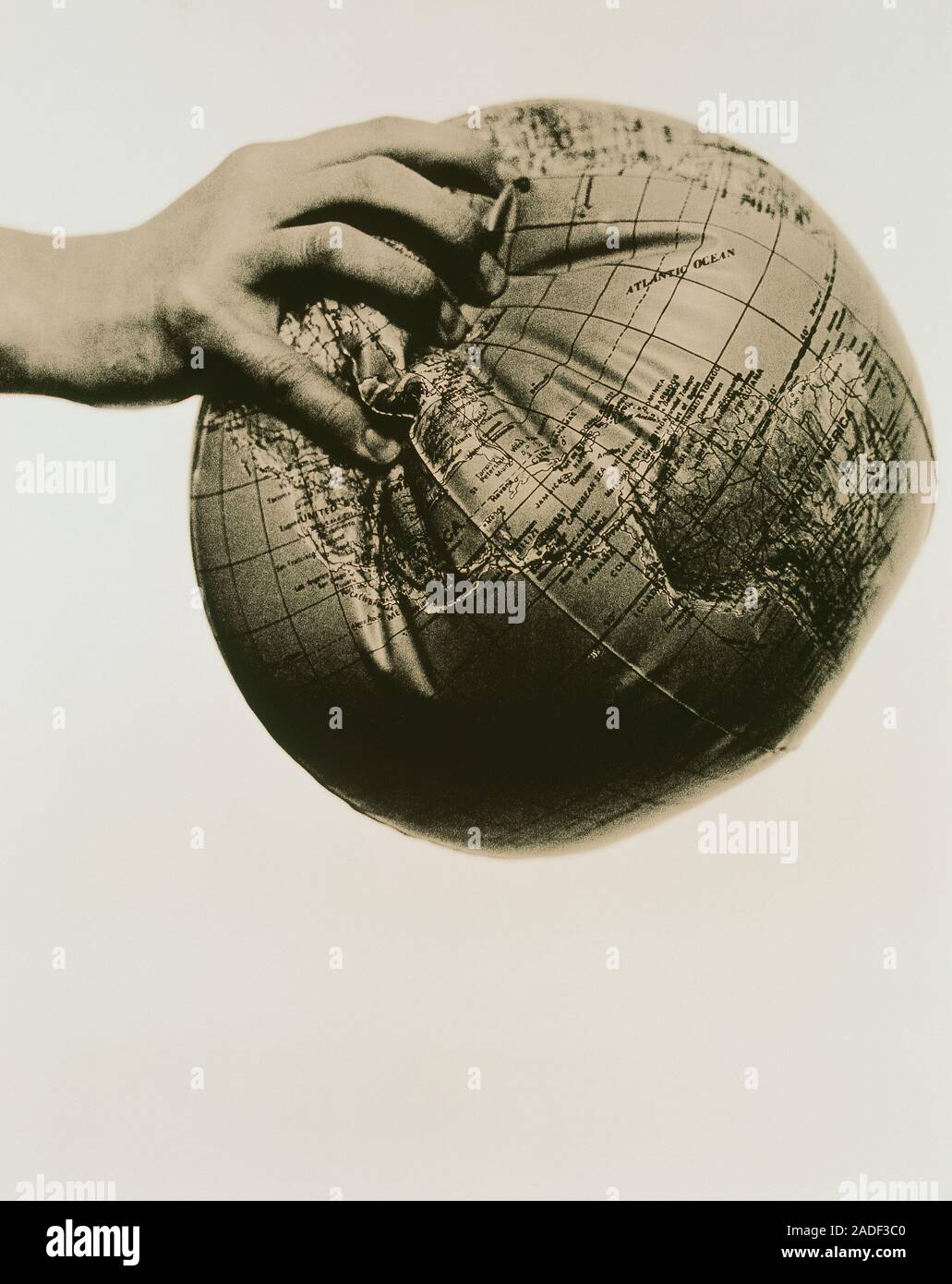 End of the world. Conceptual image of a hand crushing an inflatable ...