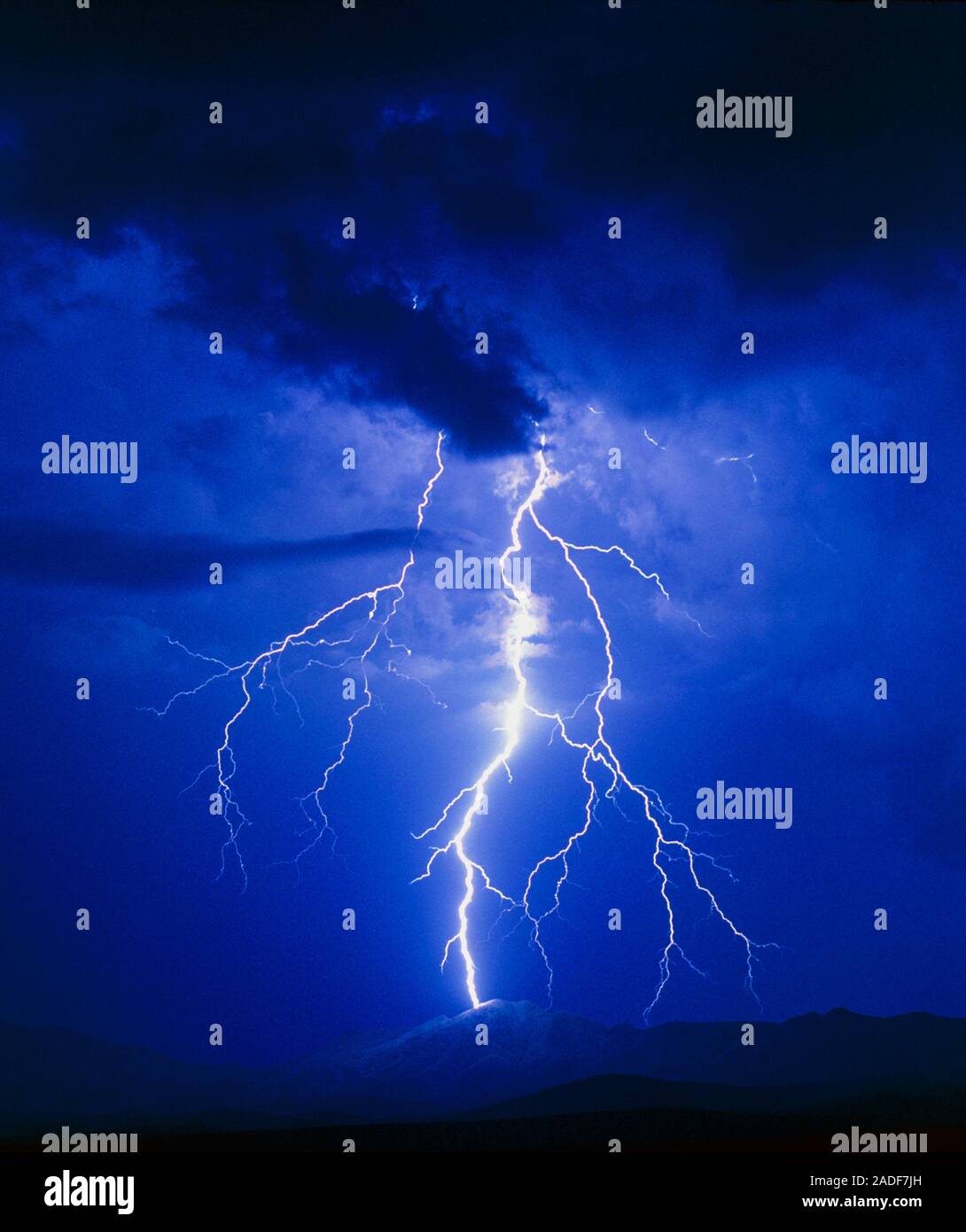 Lightning. Night-time view of a bolt of lightning striking a mountain ...