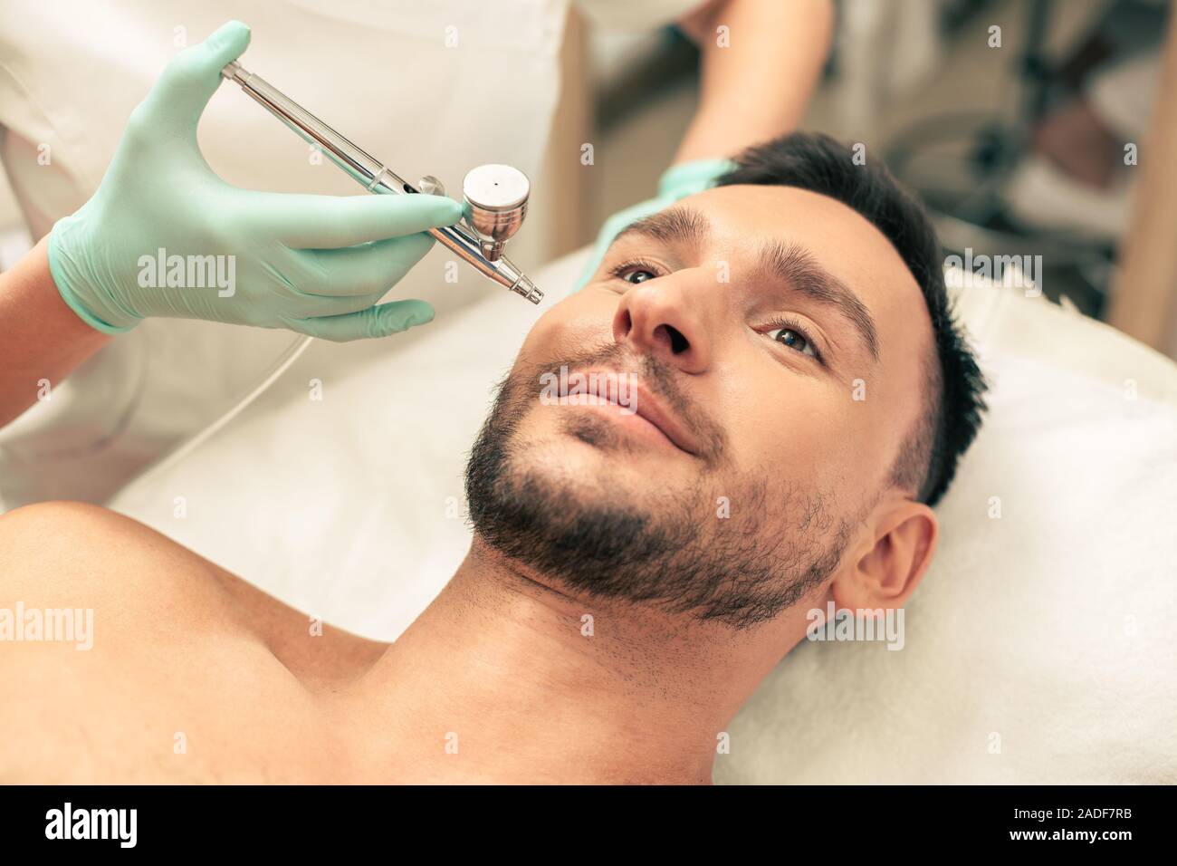 Oxygen spray treatment procedure of the young man Stock Photo - Alamy
