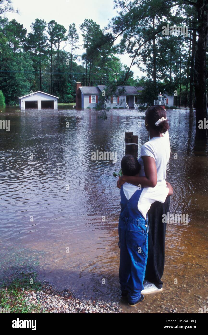 Hurricane damage. Brother and sister looking at their house, which has ...