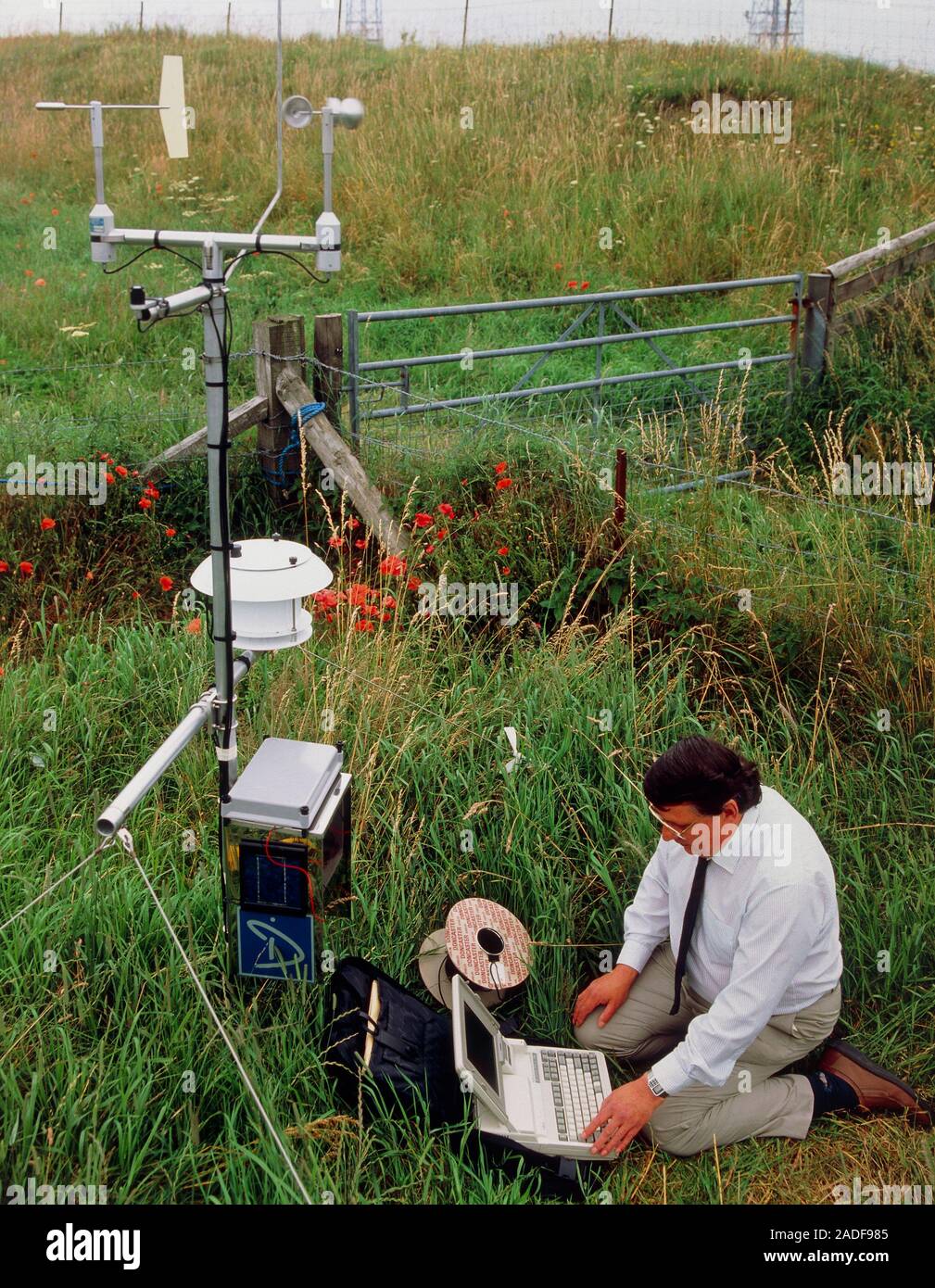 An automatic weather monitoring station located in a field. A ...