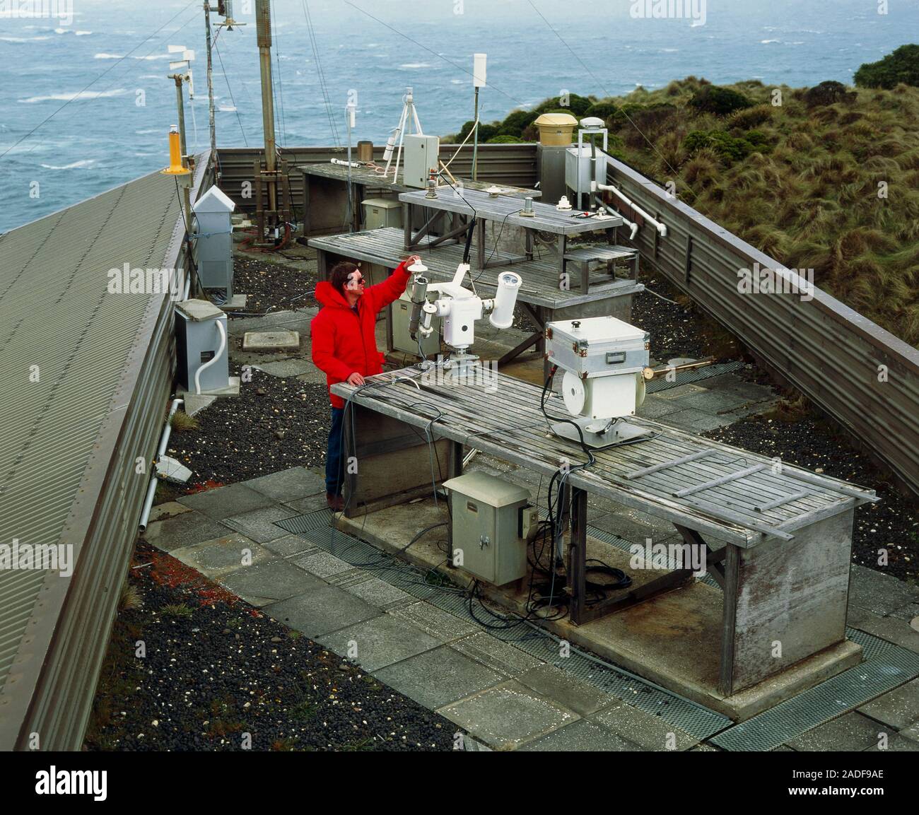Solar radiation monitor. Scientist examines a solar radiation monitor ...