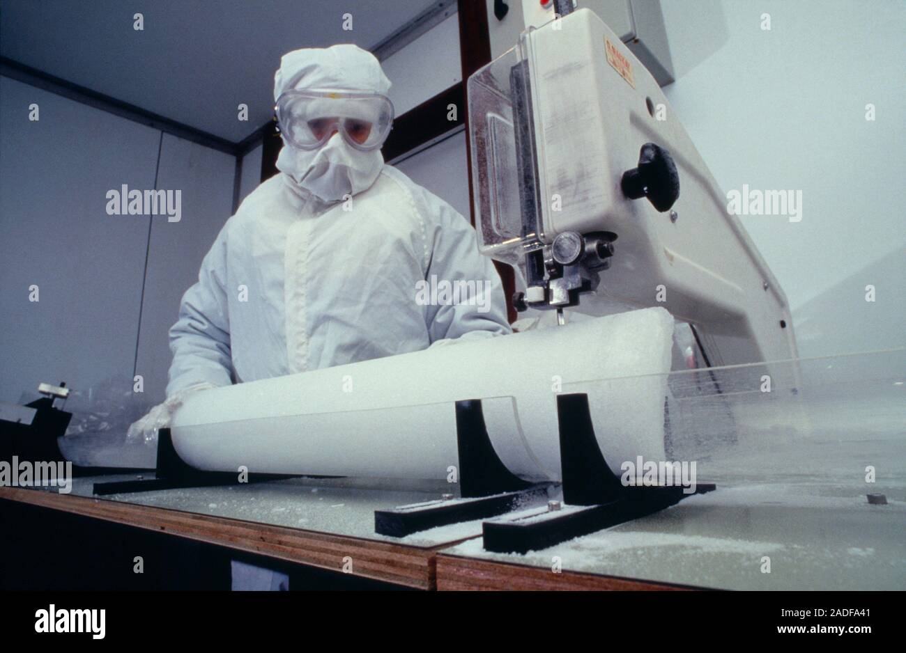 Climate change researcher. Scientist slicing an ice core sample from ...