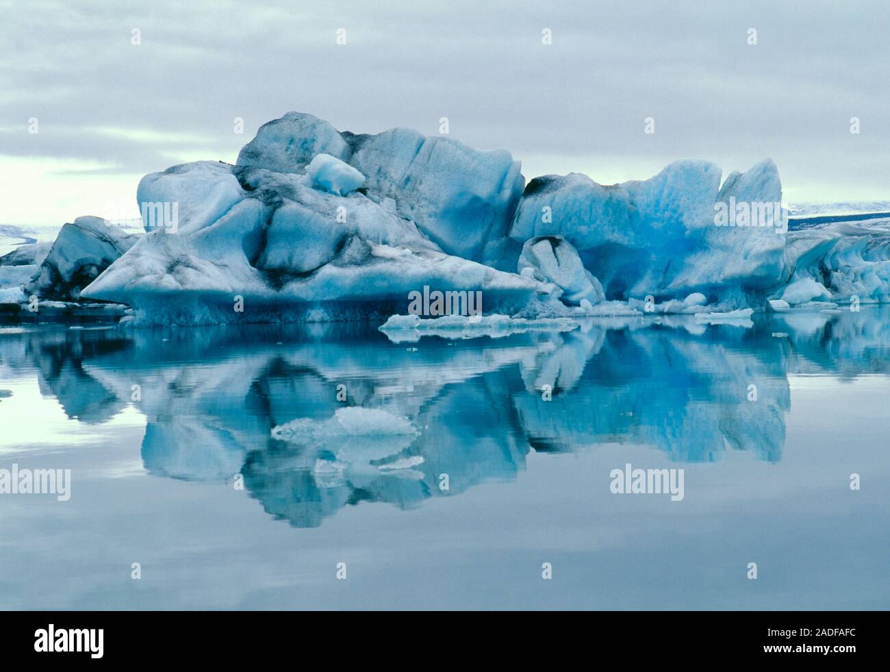 Iceberg reflected in water. This iceberg has been calved from the ...