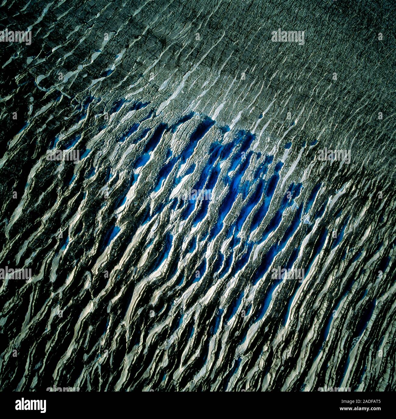 Melt water on a glacier. Aerial view of melt water in deep crevasses on ...