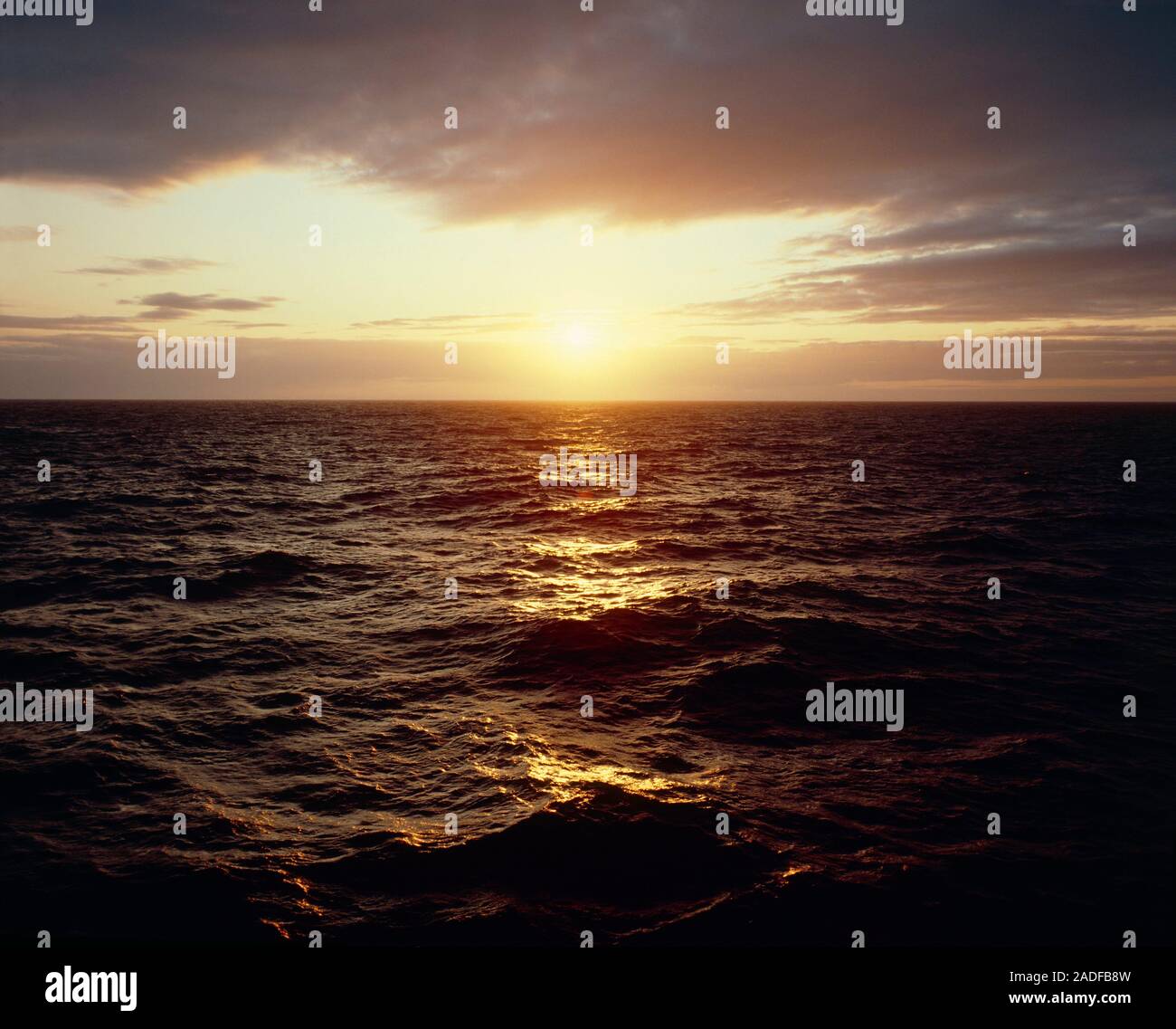 Sun setting and casting long beam across North Sea Stock Photo - Alamy