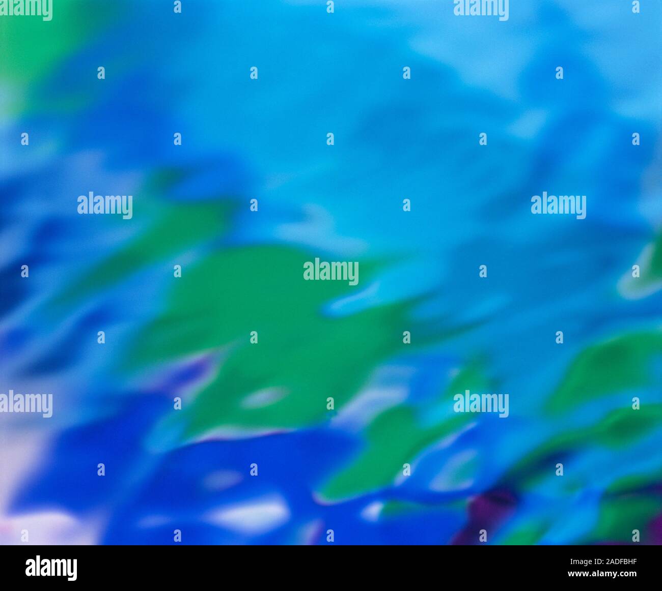 Water ripples. Reflection of coloured light off ripples on the surface ...