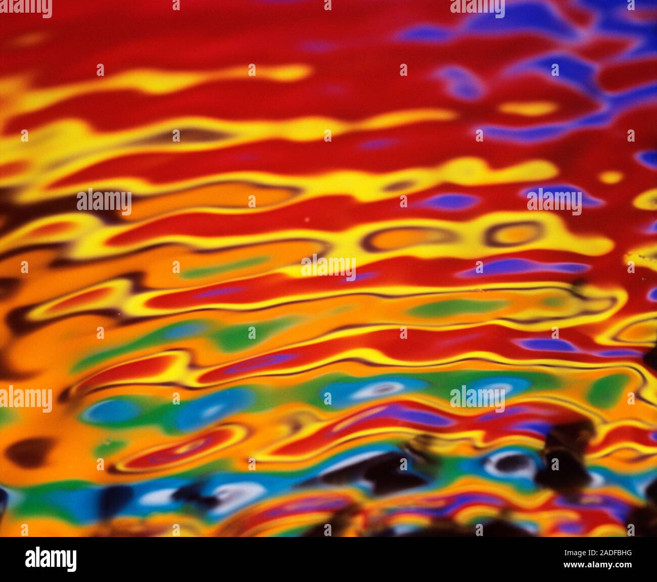 Water ripples. Reflection of coloured light off ripples on the surface ...