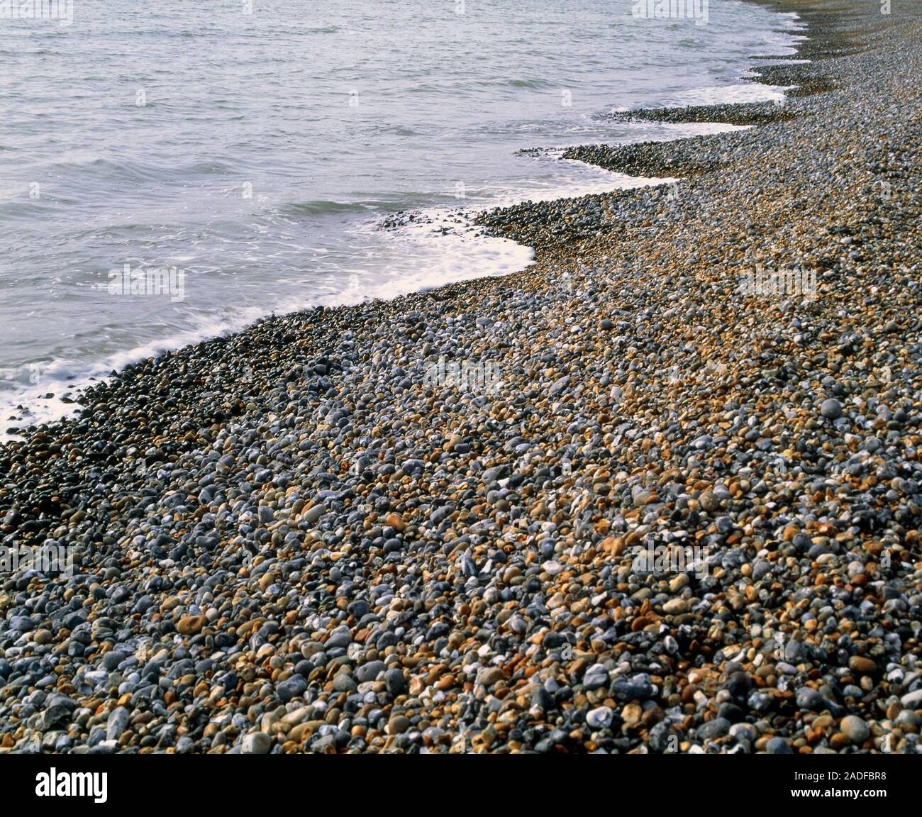 Beach. View of small rounded pebbles (shingle) on a beach. Water ...