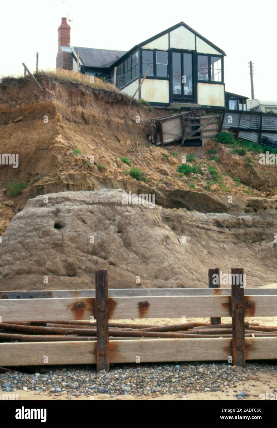 Coastal erosion. House located at the very edge of a cliff that has ...