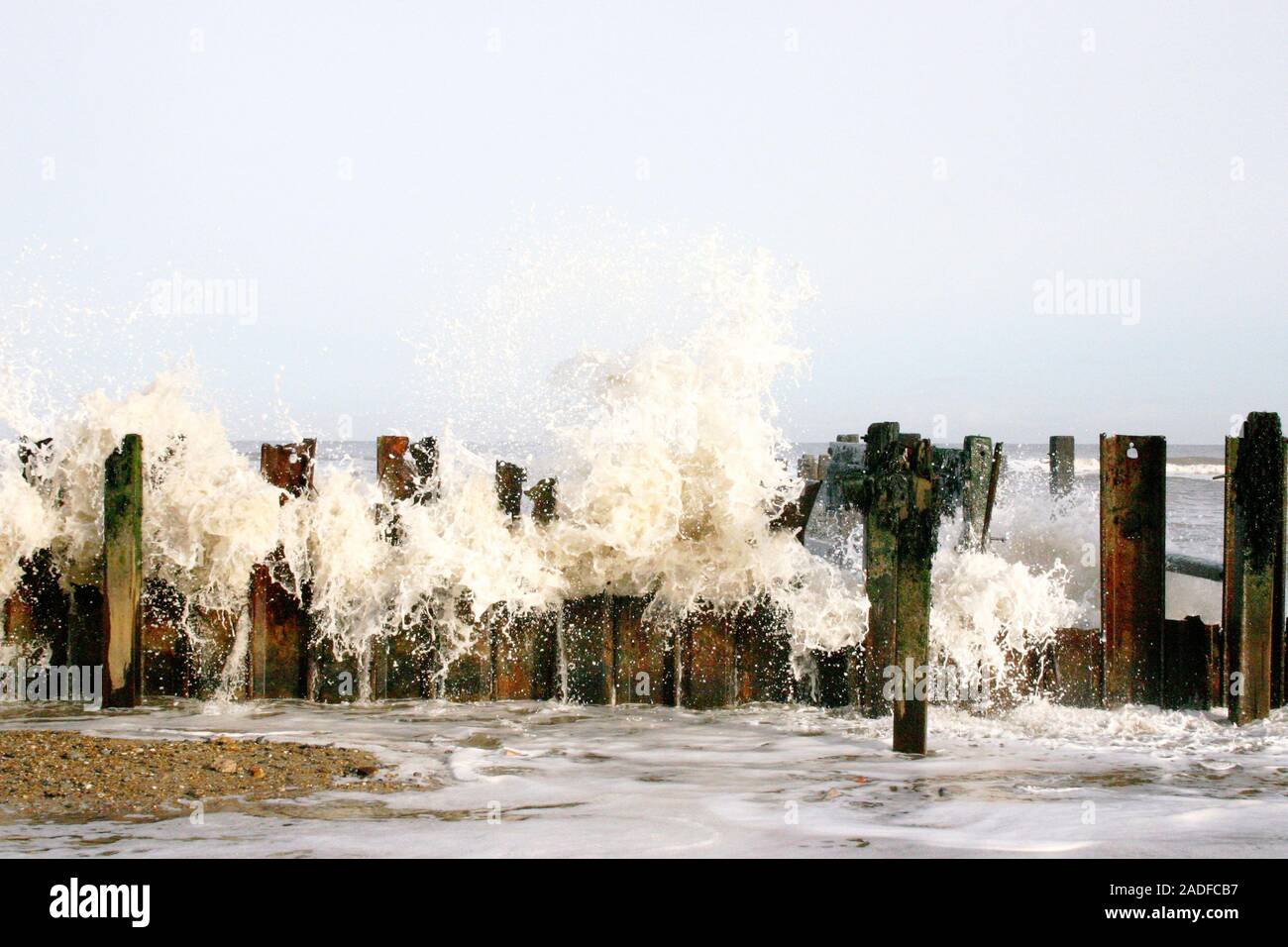 Groyne remains. Damaged wooden groynes being battered by waves on the ...