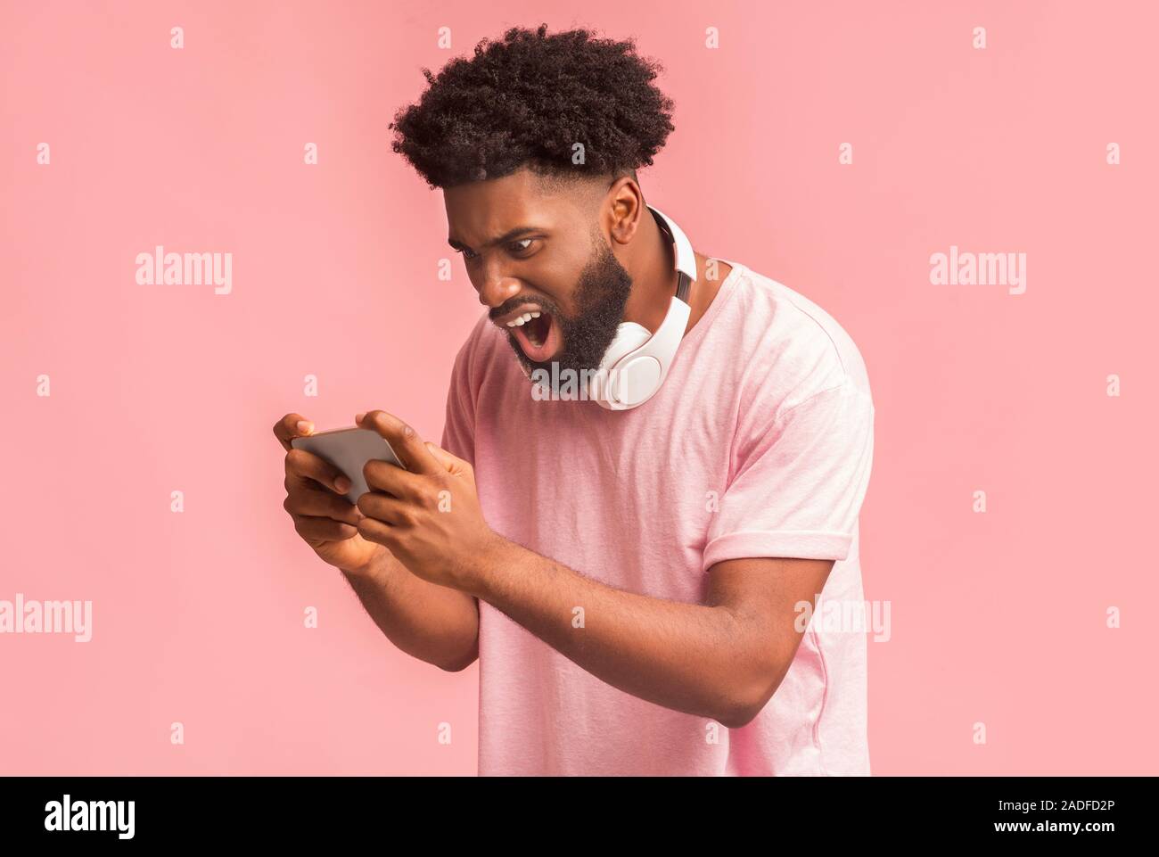 Anxious man looking at phone with angry face Stock Photo - Alamy