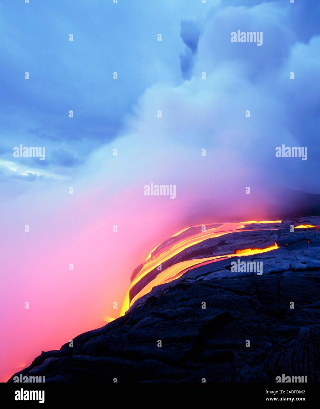 Lava flow. Steam rising as a flow of molten rock (lava) enters the sea ...