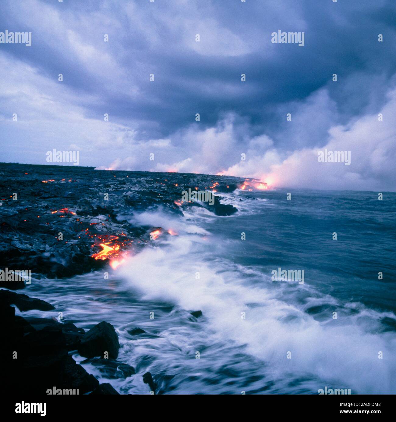 Lava flow. View of steam rising as molten rock (lava) enters the sea on ...