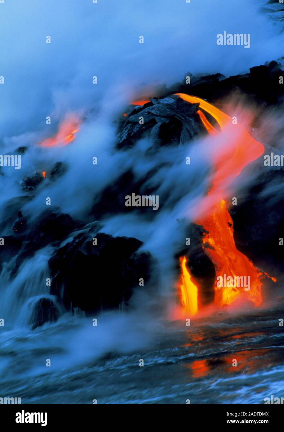 Lava flow. Rising steam caused by glowing orange lava boiling sea water ...