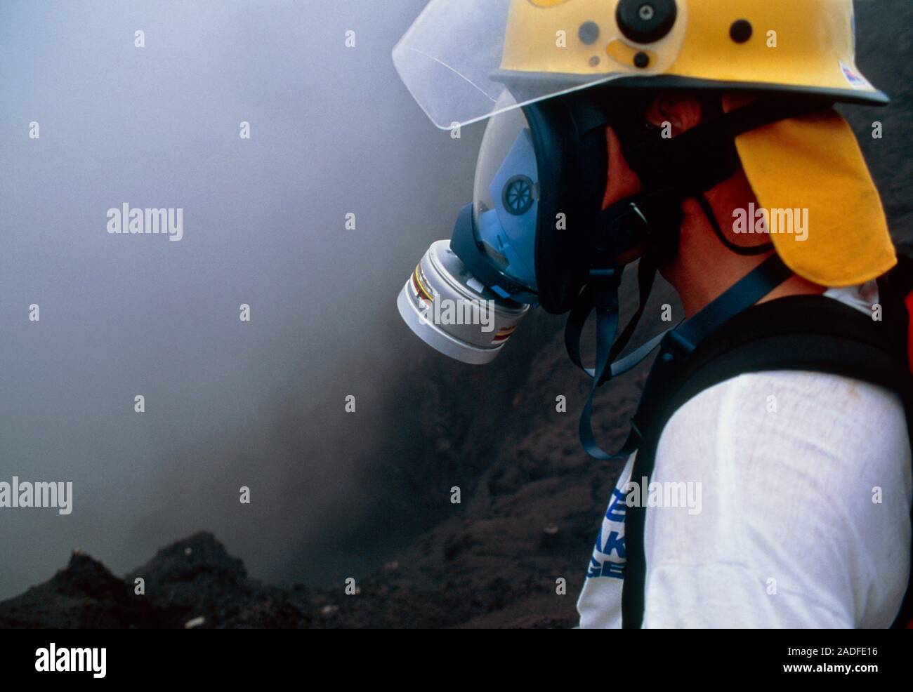 Volcanologist wearing a gas mask to protect him from the potentially ...