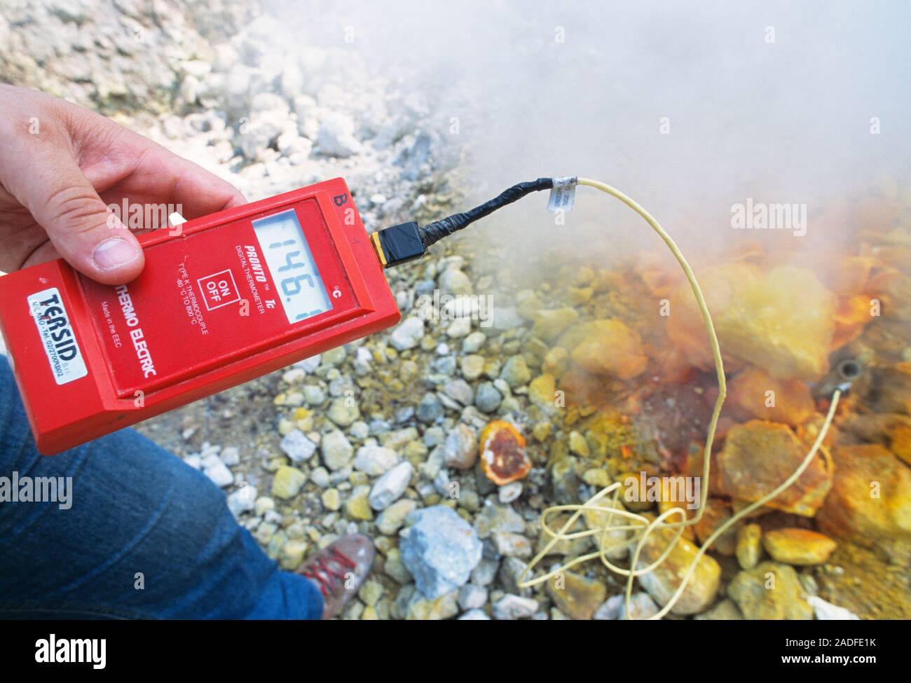 Measuring volcanic temperature by a volcanic vent (or fumarole). Hand ...