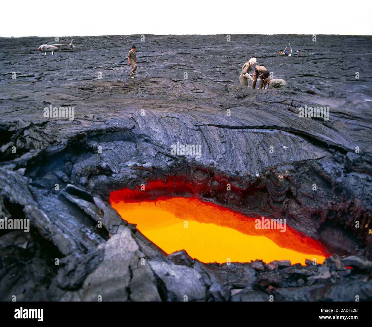 Lava flow research. Vulcanologists studying a lava flow on Kilauea ...