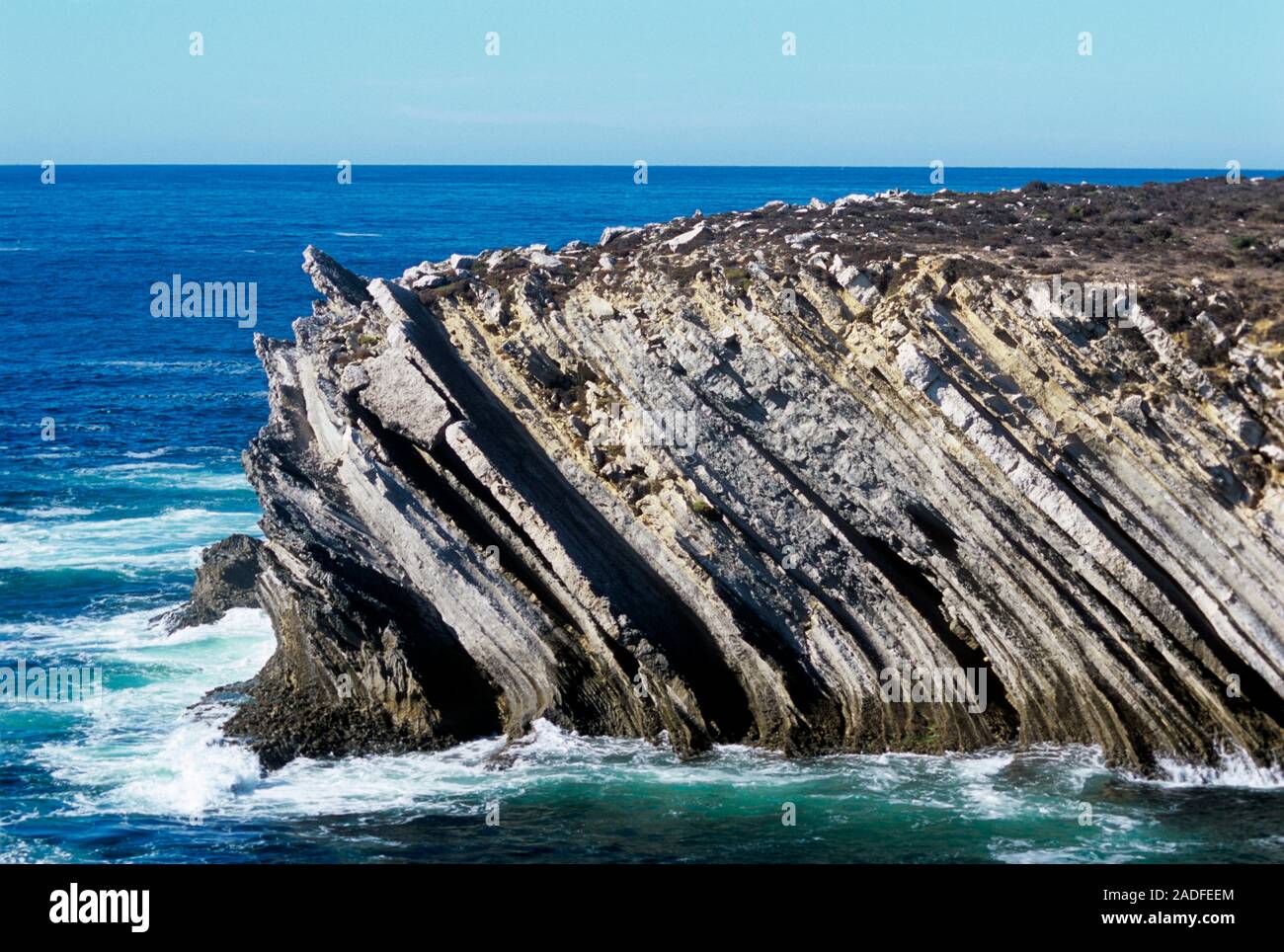 Rock strata revealed in eroded coastal rocks. The diagonal strata seen ...