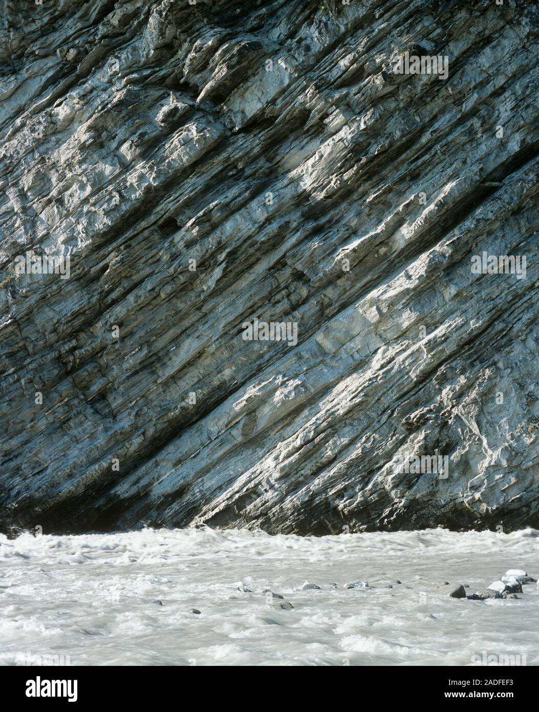 Inclined rock strata revealed in eroded rock. The strata seen here were ...
