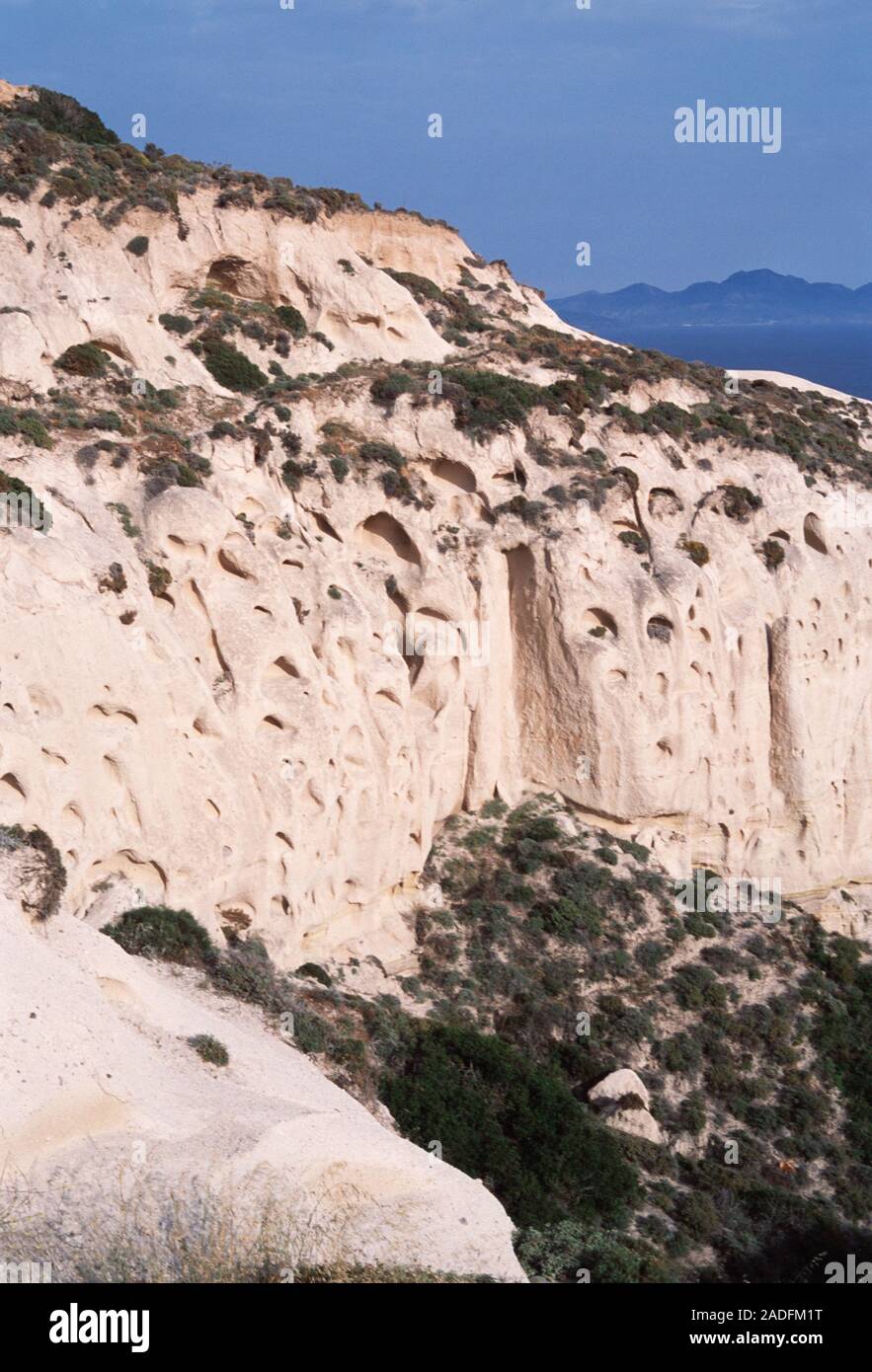 Wind erosion. Cliff face showing cavities caused by wind-borne sand ...