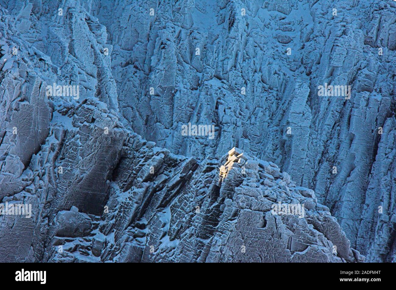 Weathered granite. Light illuminating rocks in the steep headwall of a ...