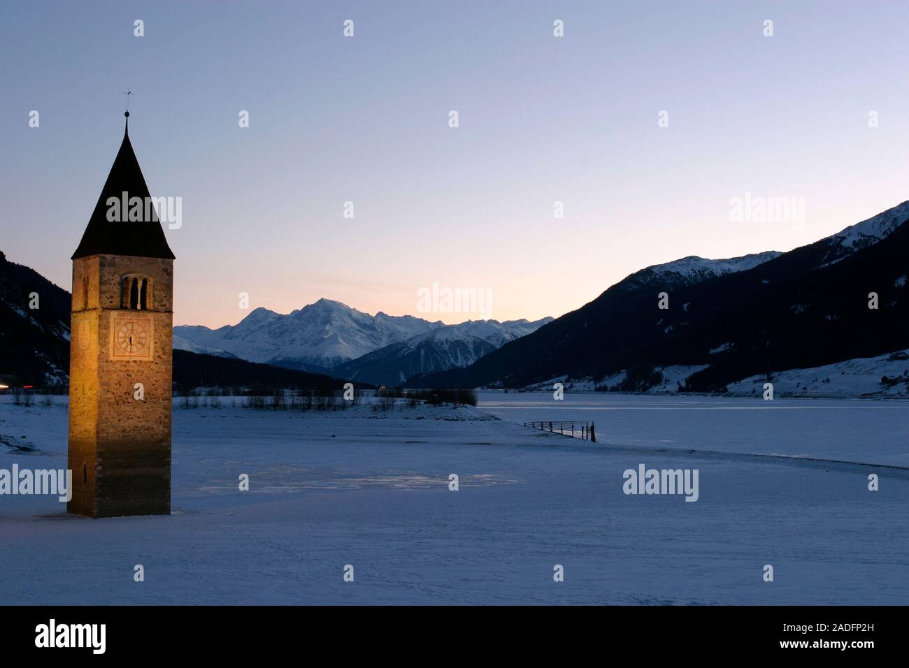 Drowned clock tower frozen in ice. This is the Reschen reservoir in the ...
