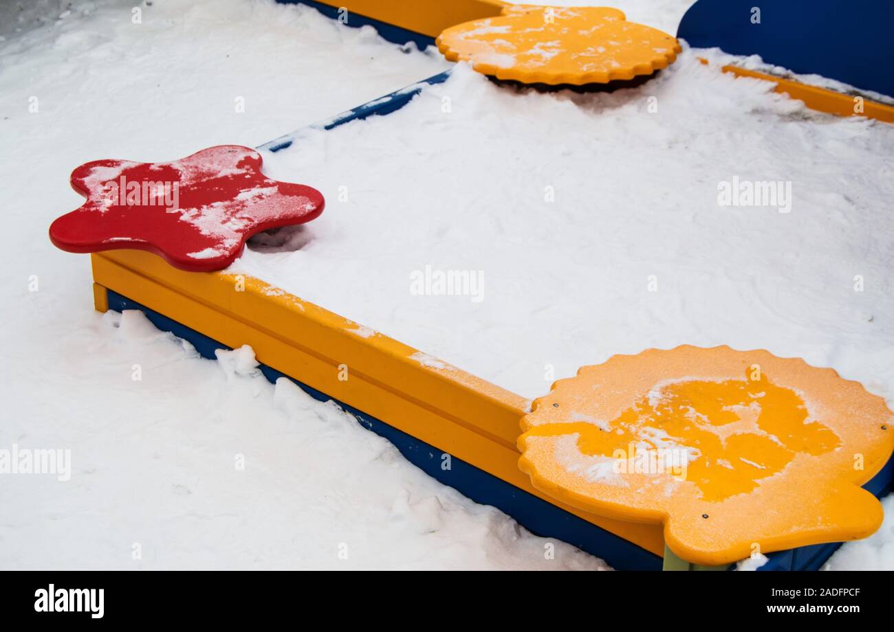 Colorful children's sandbox covered with snow on a winter day in the ...