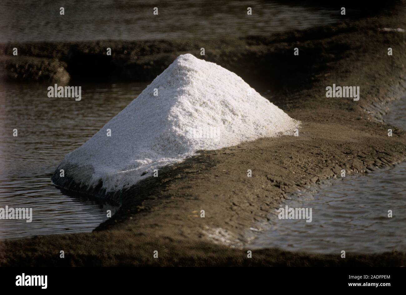 Pile of extracted salt next to a salt pan. Salt pans are pools of sea ...