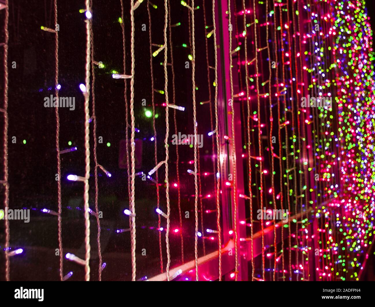 Multi-colored and red led lights on the building during the holiday ...