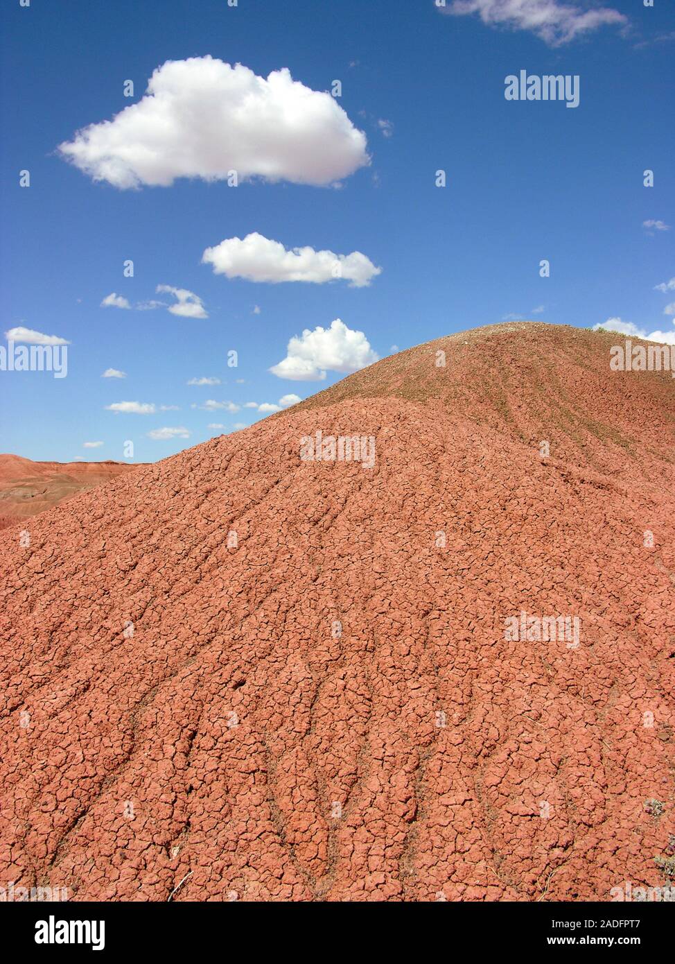 Dried mud slopes in a desert. The uneven surface of the slopes is ...
