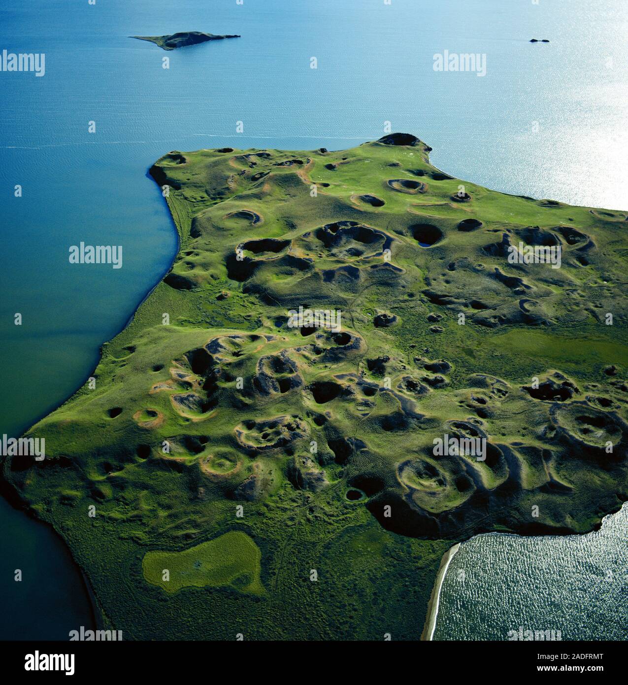 Volcanic island. Aerial photograph of a lush green volcanic island off ...