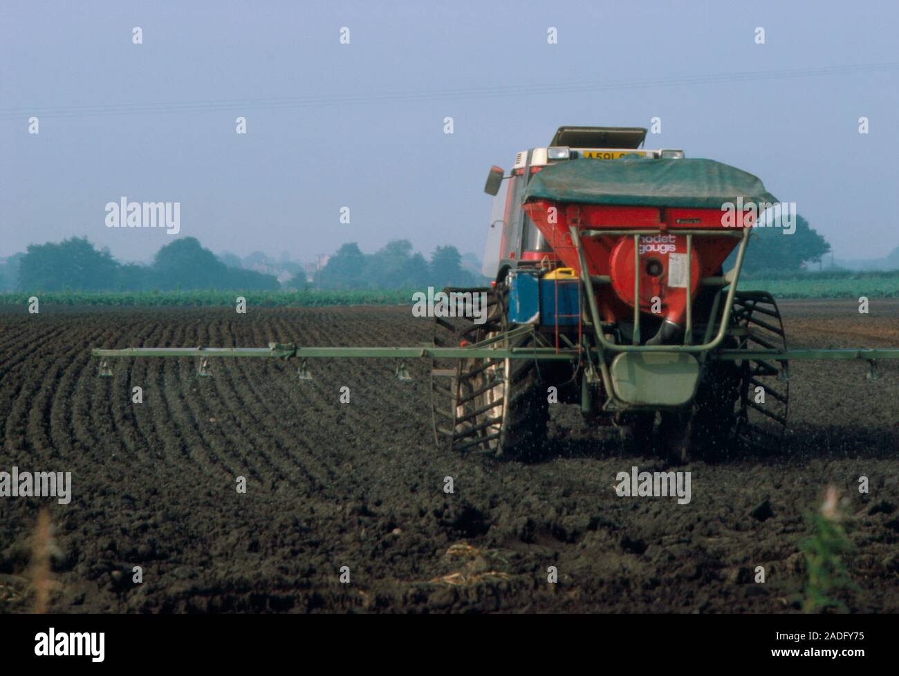 Tractor spreading fertilizer over ploughed land Stock Photo - Alamy