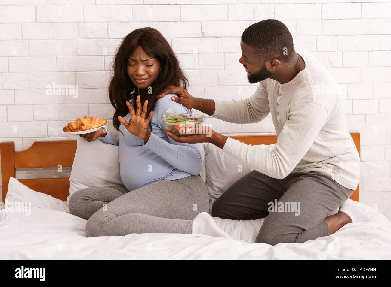 Husband begging his pregnant wife eat healthy food Stock Photo - Alamy