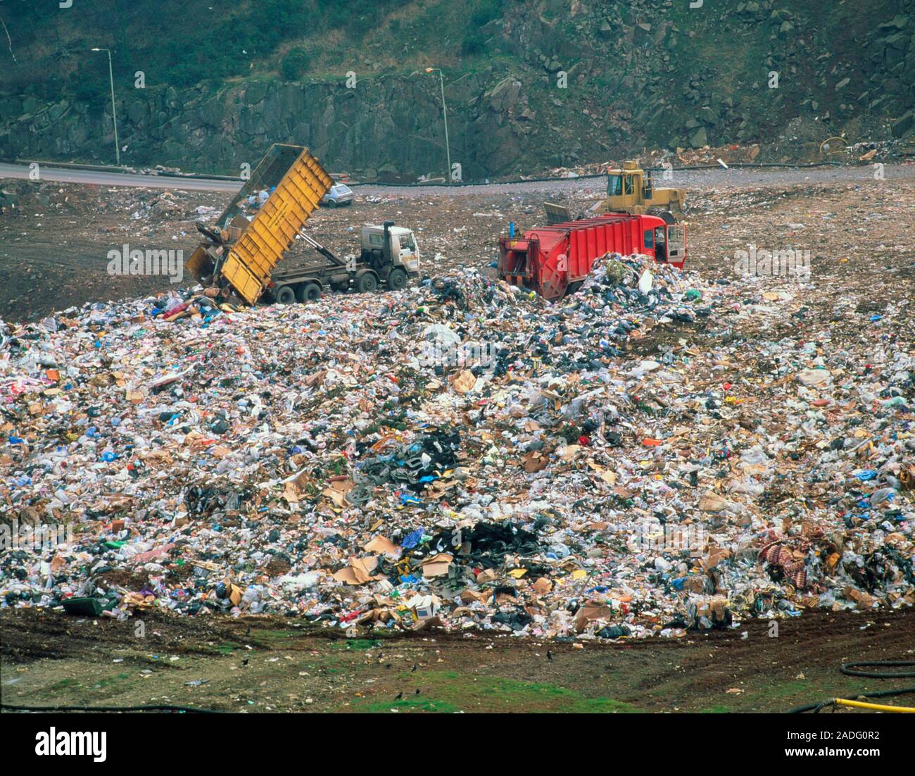 Landfill site with waste-disposal lorries emptying their loads ...