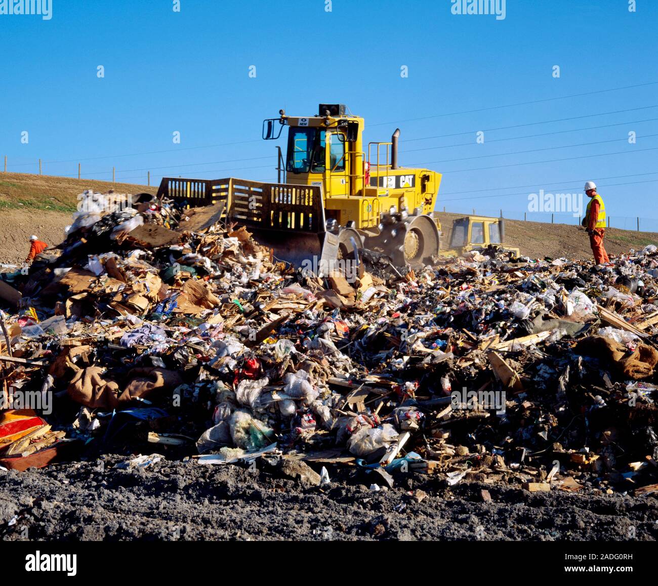 Waste landfill site. A bulldozer levels refuse dumped at a landfill ...