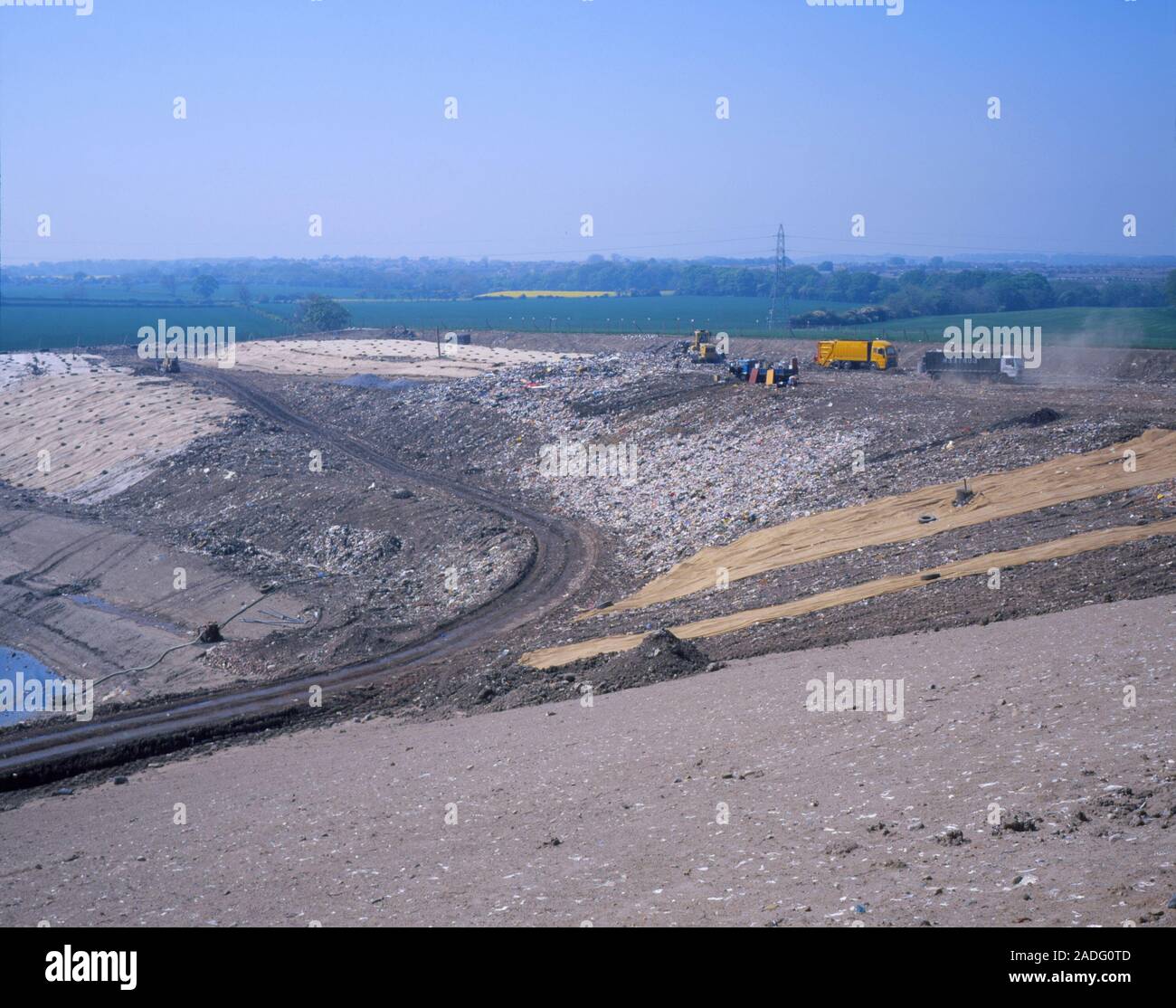 Waste landfill site. Waste trucks and bulldozers operating at a ...