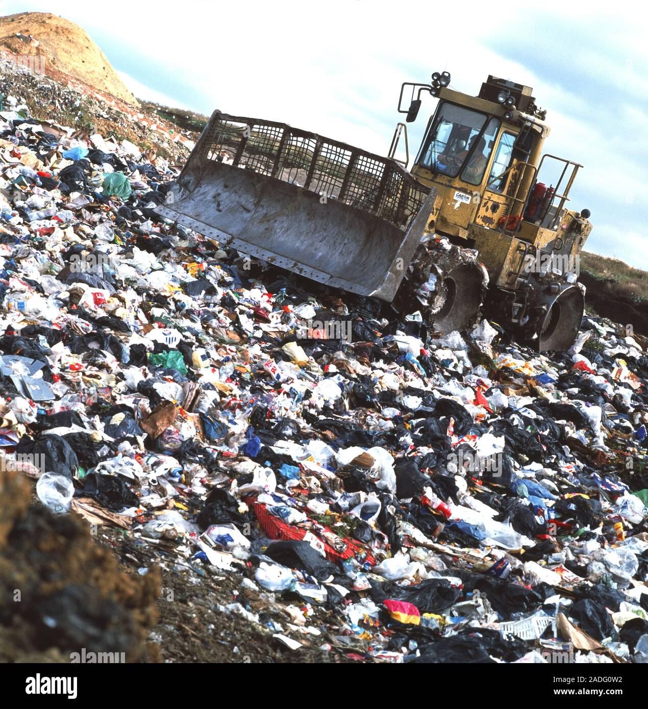 Waste landfill site. View of a bulldozer working in a waste landfill ...