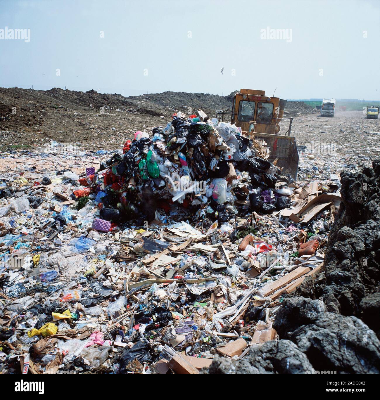 Landfill site. Bulldozer moving rubbish around at a landfill site ...