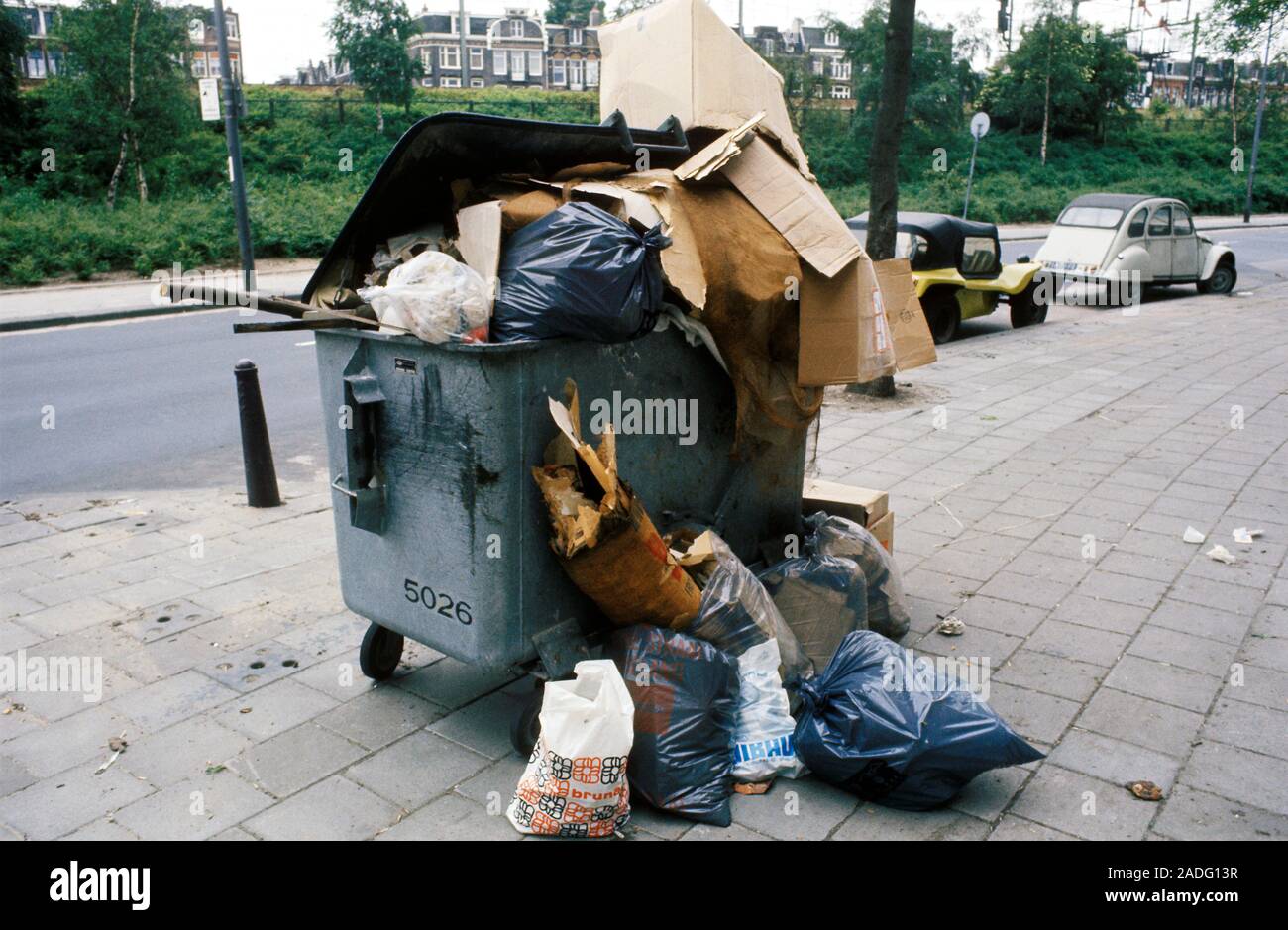 Overflowing rubbish bin on the pavement Stock Photo - Alamy