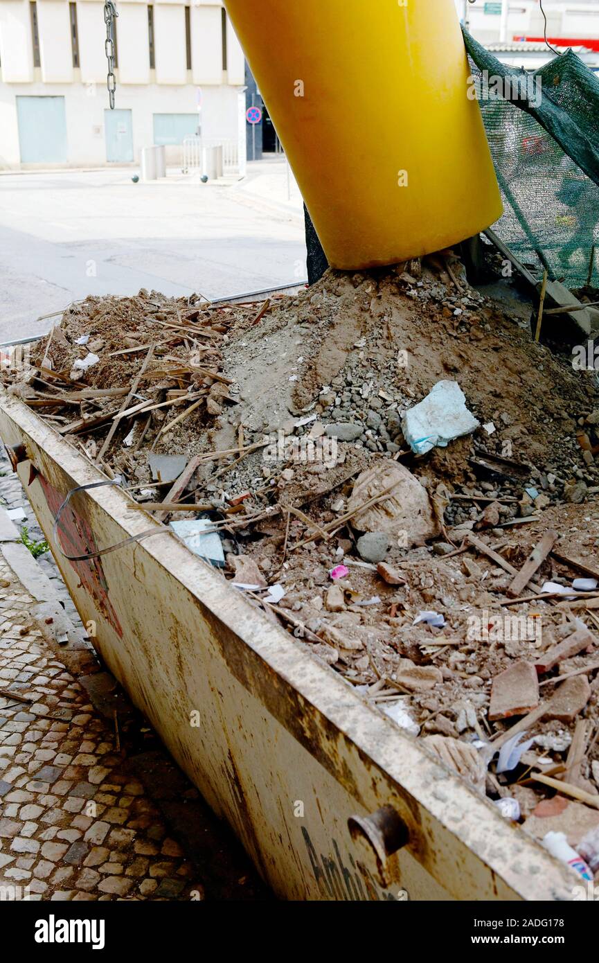 Skip containing building rubble from construction work in a street ...
