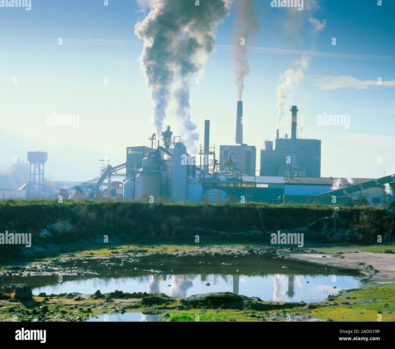 Industrial air pollution. View of a paper mill producing large ...