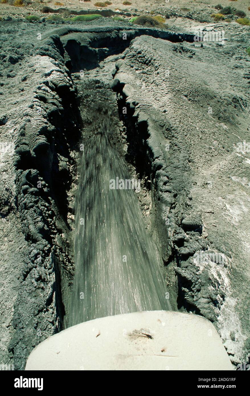 Mining pollution. Sludge flowing from a pipe. Water has been used to ...