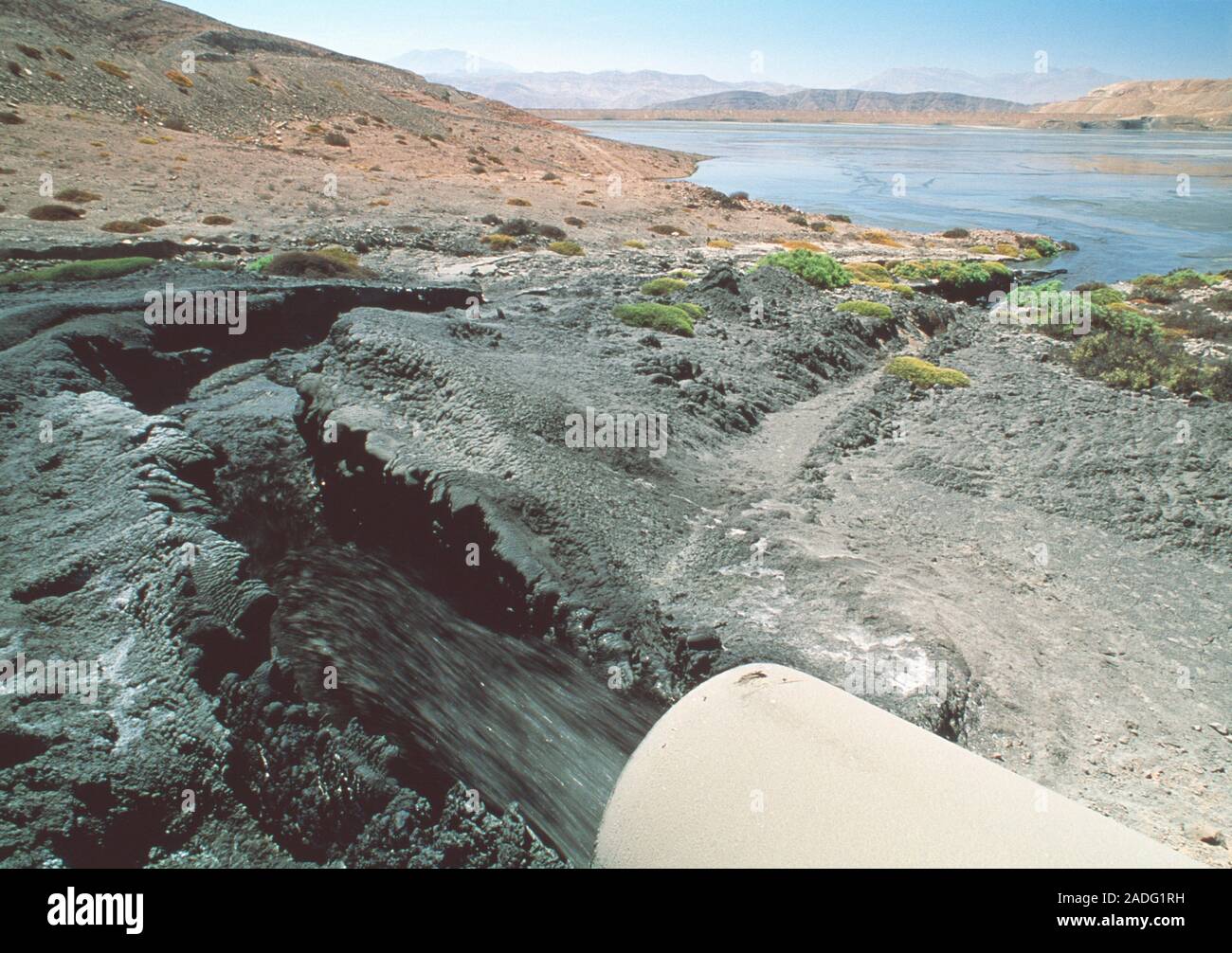 Mining pollution. Sludge flowing from a pipe. Water has been used to ...