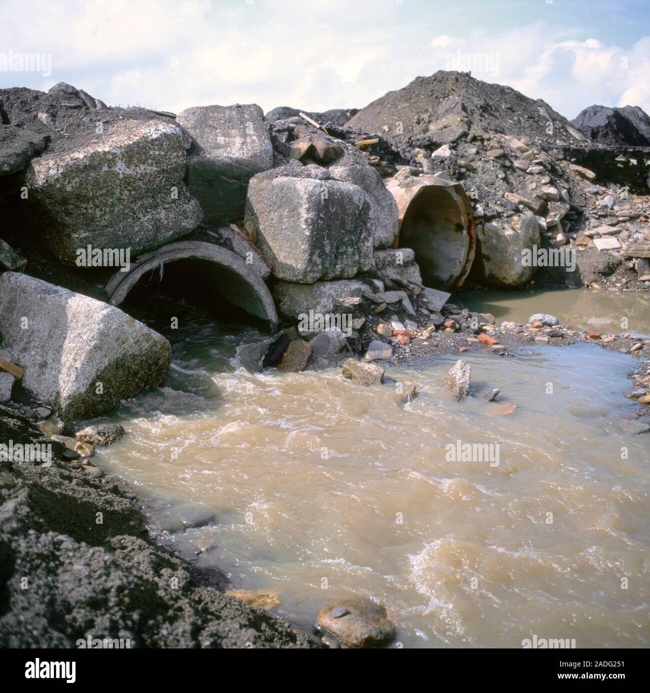 Industrial pollution. Outflow pipes discharging wastewater from a mine ...