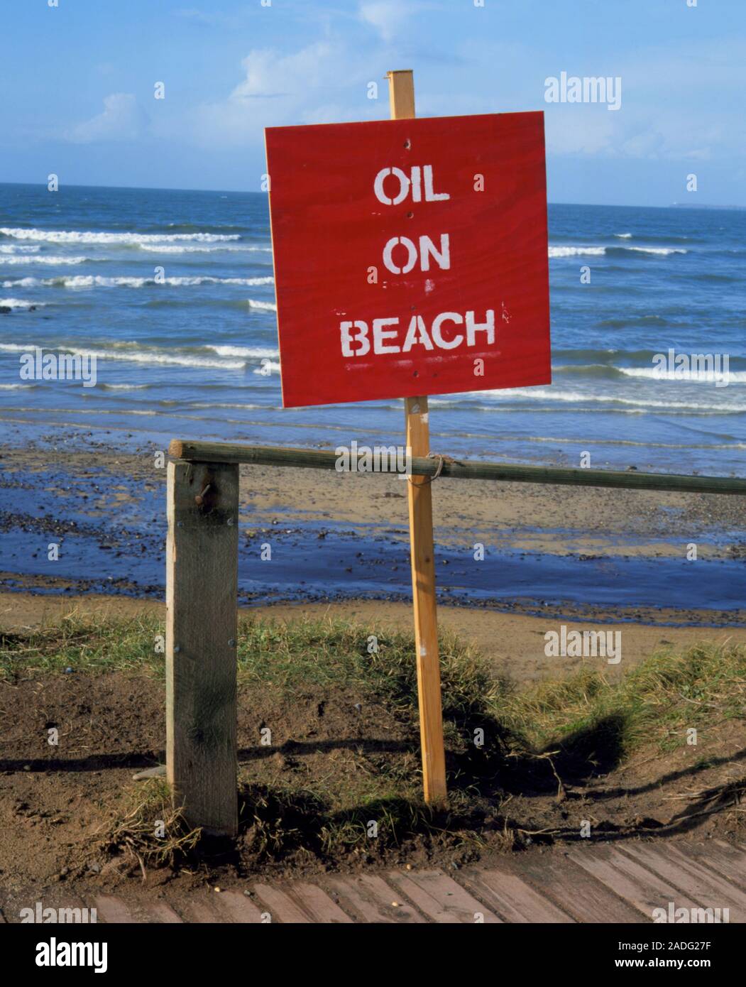 Oil pollution sign. Coastal sign warning that the beach is polluted by ...