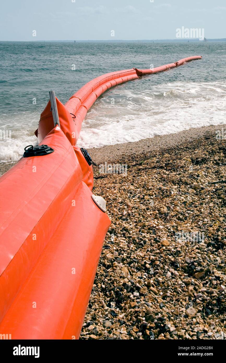 Pollution control. Inflatable boom across a shoreline. A boom is an ...