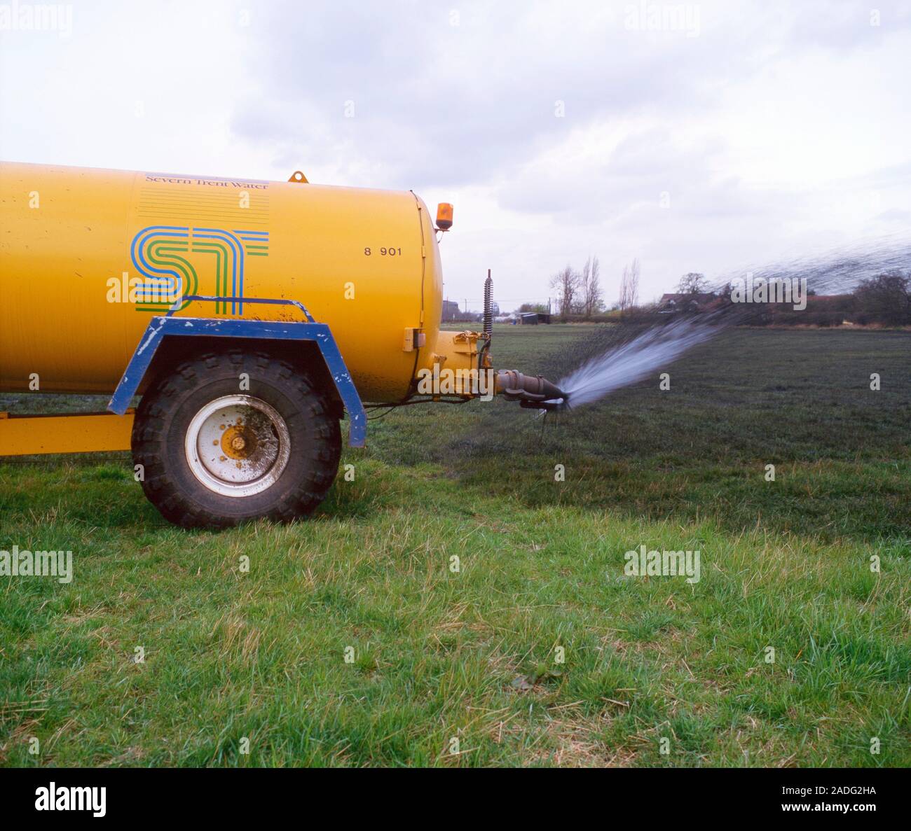 Sewage sludge disposal. Sewage sludge being sprayed onto a field as a ...